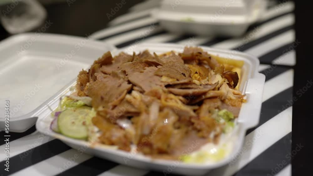 Man eats kebab with fork close-up. White plastic box package with doner ...