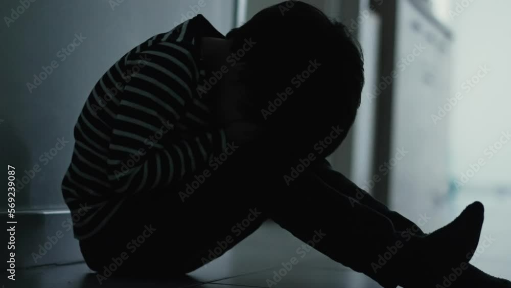 Fearful kid suffering from bullying and trauma sitting on floor ...