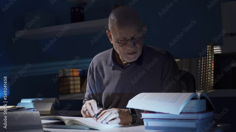 Researcher or historian mature old man reading a book, taking notes ...