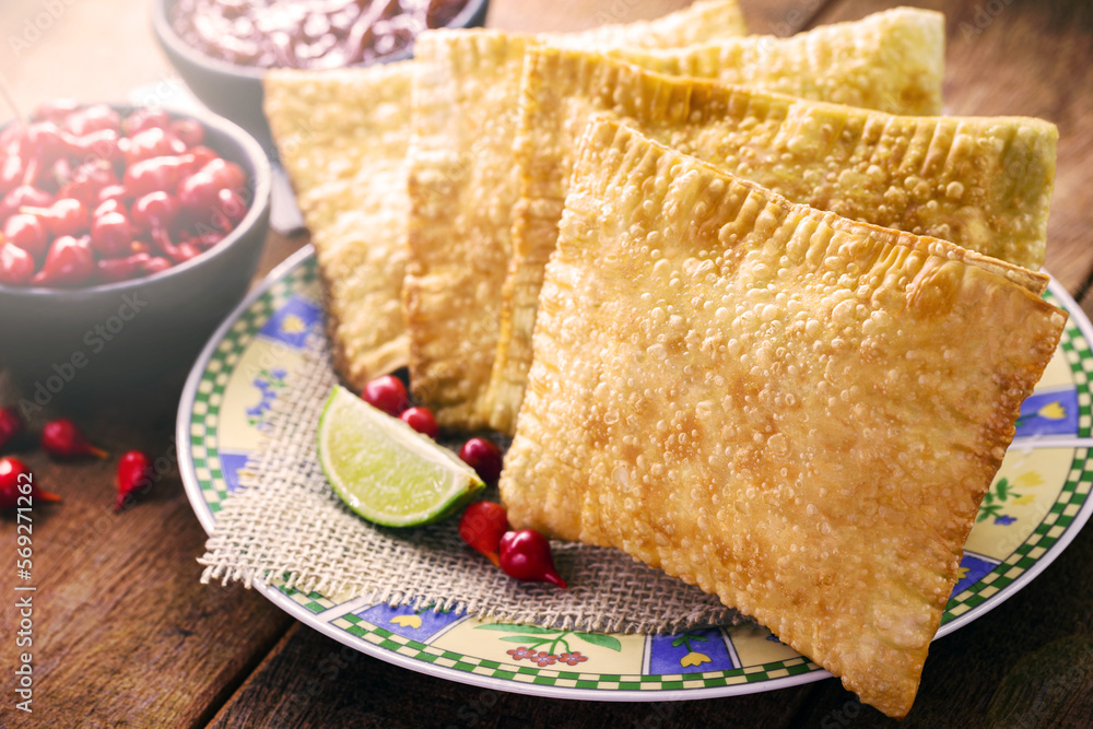 Brazilian pastry, traditional fried dough called pastel with lemon or ...