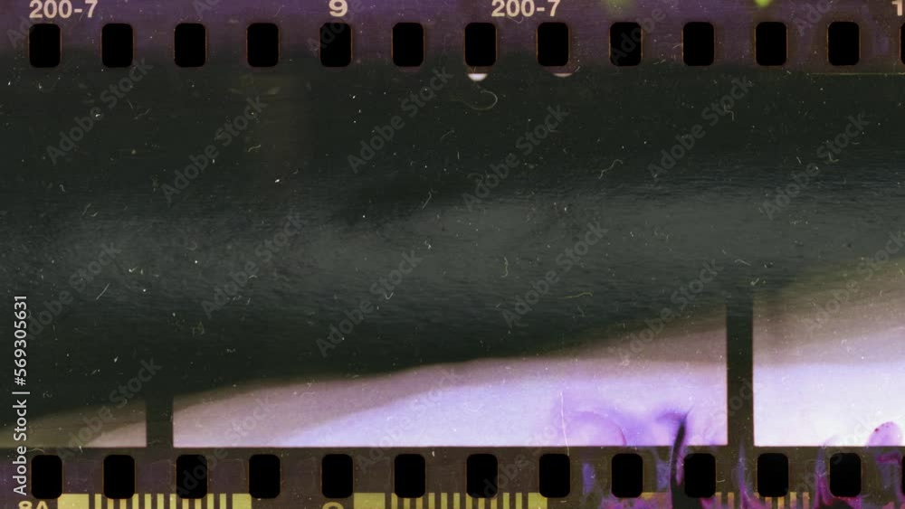 scan of dark underexposed 35mm film strip with developing smear marks ...