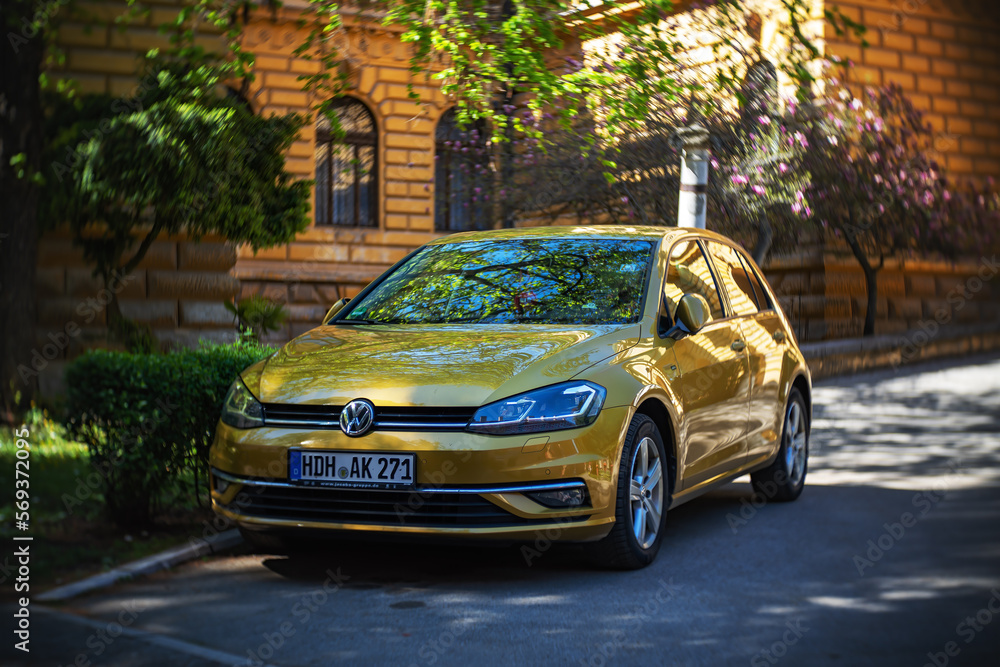 Beautiful golden color Volkswagen Golf 7 is parked in square of ...
