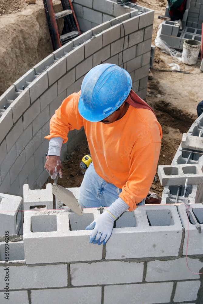 Mason installing a structural block retaining wall Stock Photo | Adobe ...