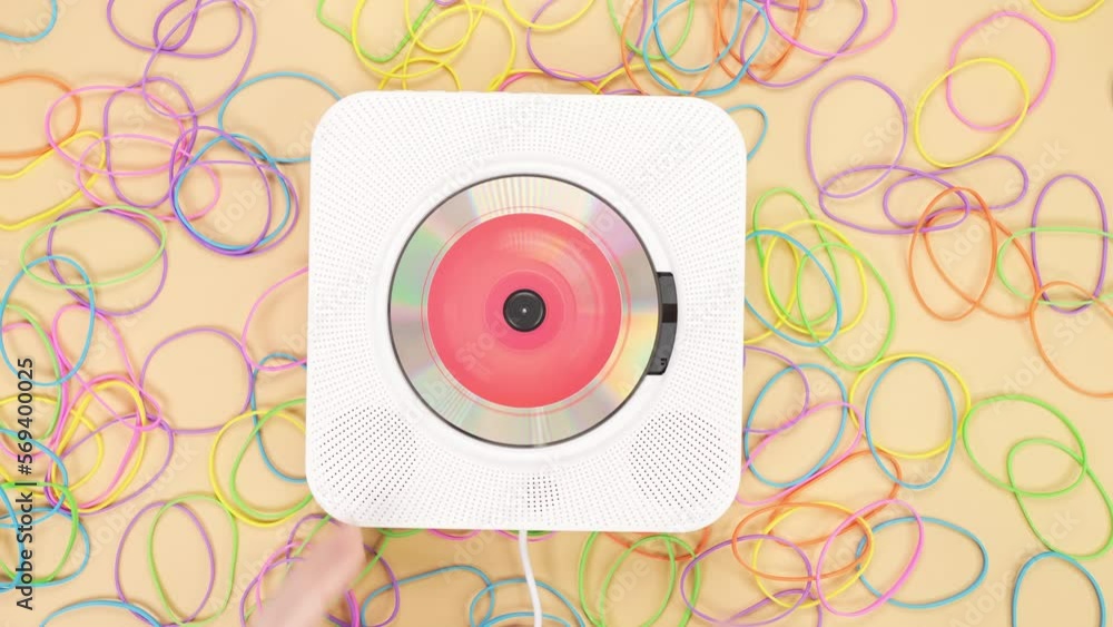 Hands put vintage white stylish portable CD player on bright yellow ...