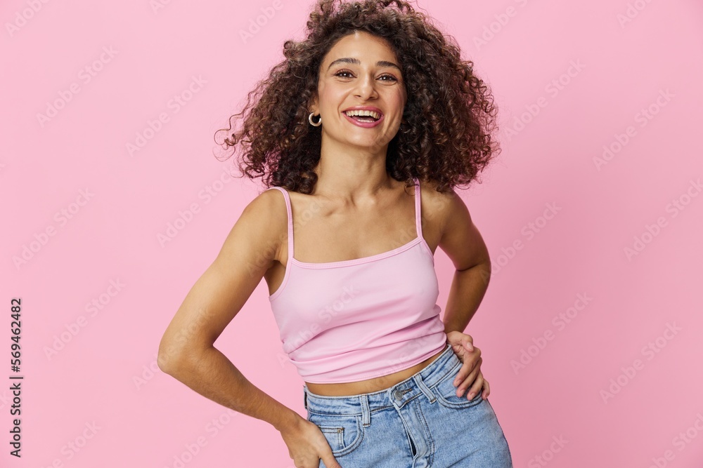Foto de Woman with curly afro hair model poses on a pink background in ...