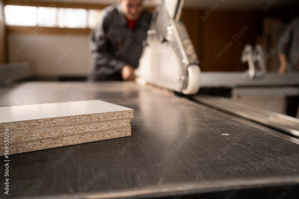 Foto de Carpenter working with sliding panel saw and sawing mdf board ...