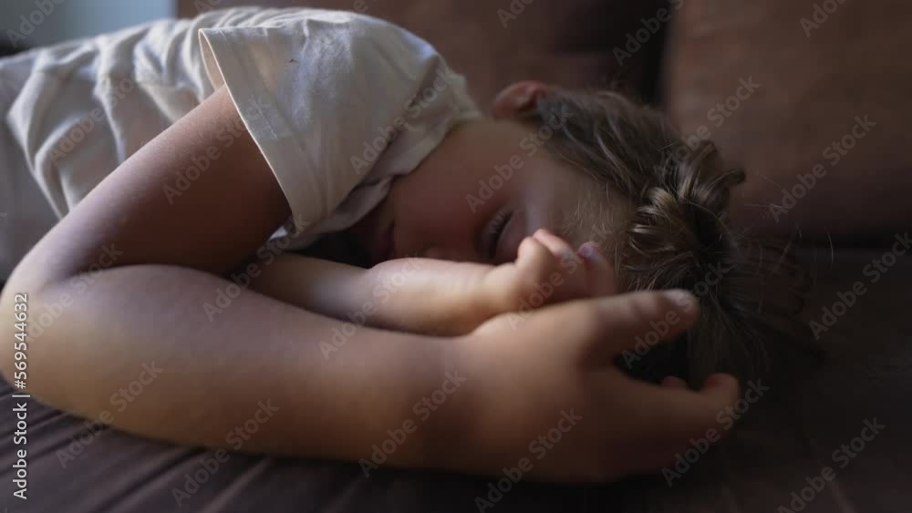 Sleeping child lying on couch napping. Kid in deep slumber asleep during afternoon nap. Cute ...