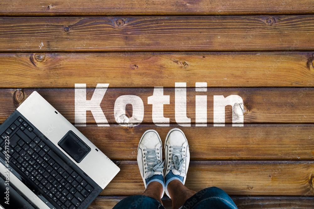 Kotlin Mobile Application Programming Language Legs In Shoes Standing Next To Laptop And Word