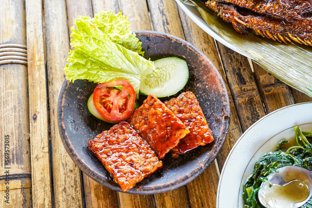 Grilled tempeh or fried tempeh with red barbecue sauce, vegetables and ...