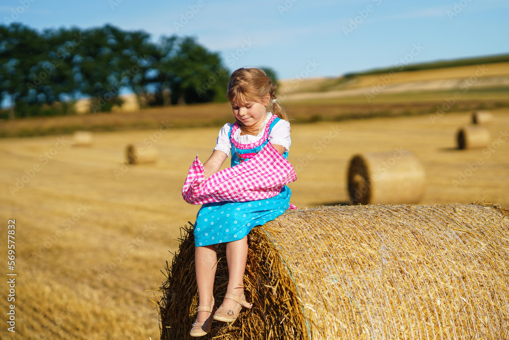 Cute little kid girl in traditional Bavarian costume in wheat field ...