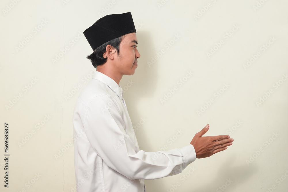 pose of asian man wanting to shake hands. portrait of an indonesian man ...