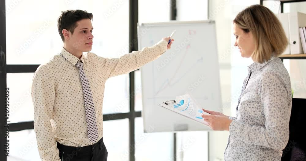 Woman is looking at chart on clipboard and an intern student is ...