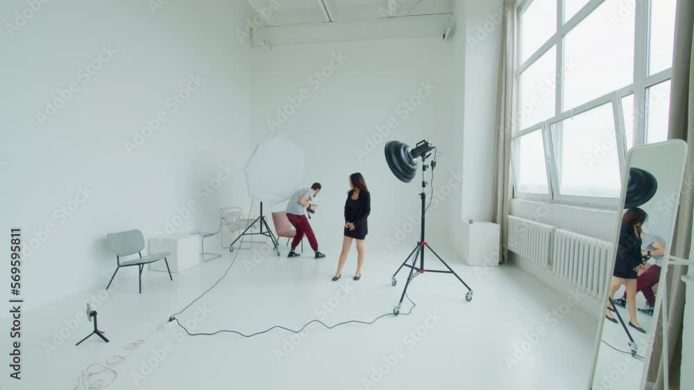 Male photographer shoots beauty portraits of female model in white ...