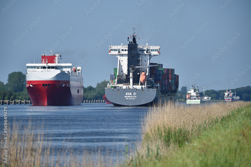 Containerschiff und Frachtschiffe begegnen sich in einer Ausweichstelle im Nord-Ostsee-Kanal ...
