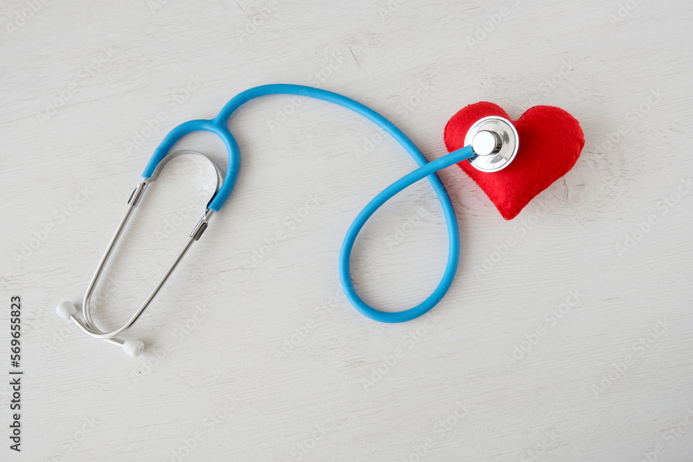 Heart soft toy and stethoscope on a light background. Children's first ...