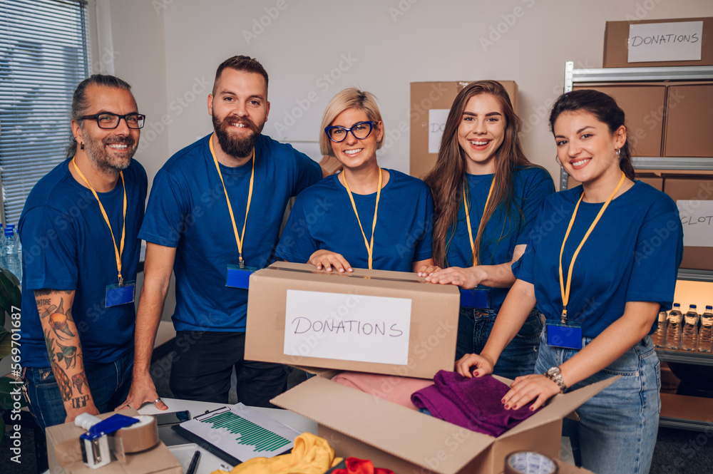 Diverse volunteers working in a charity donation center and packing ...