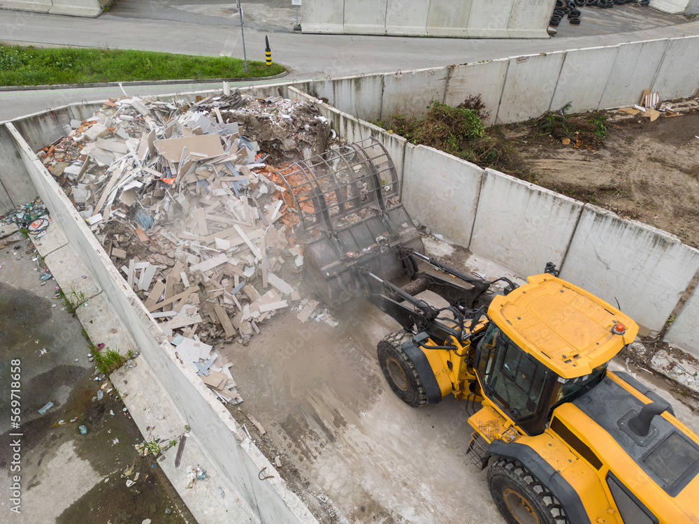 Foto de Handling construction waste on the landfill site, skid steer ...