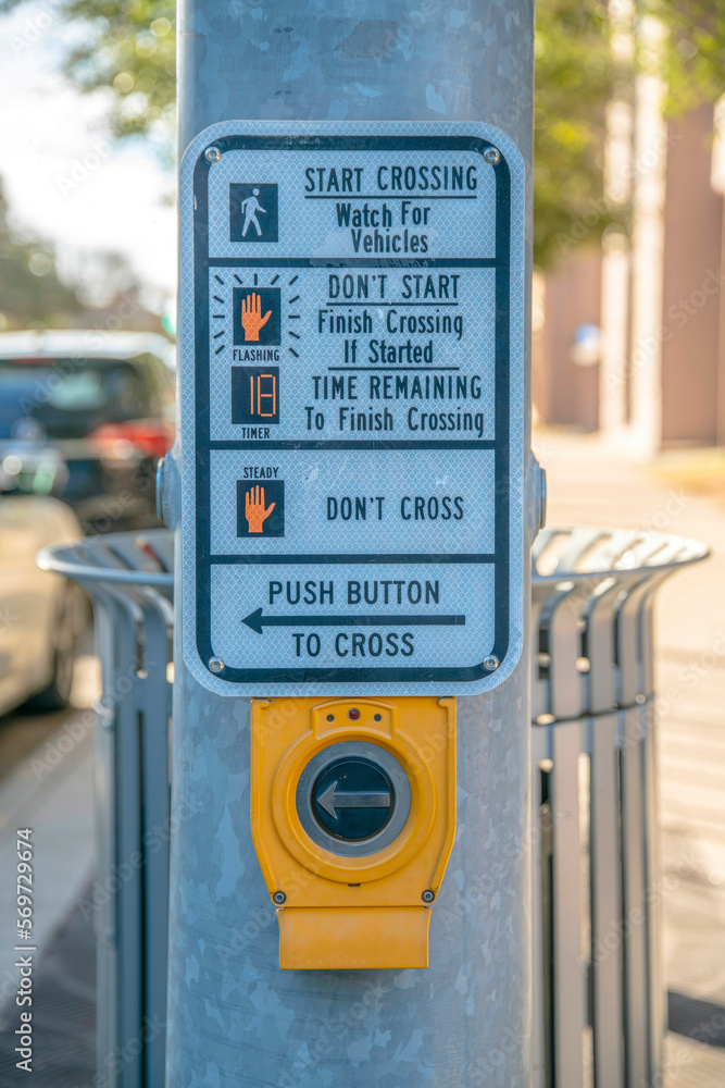 Push button at crosswalk with signage on a post at Austin, Texas. Close ...