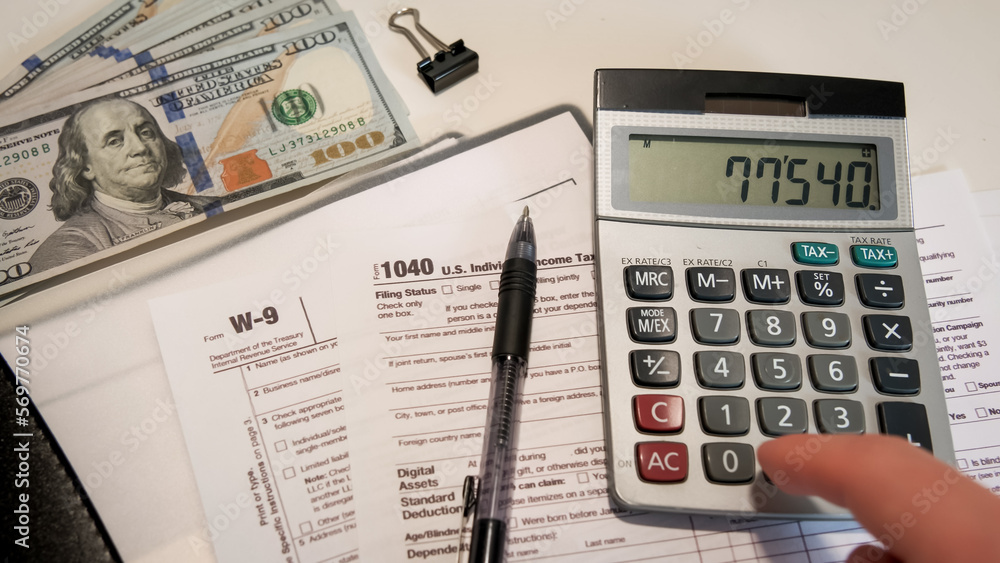 Top view of calculate the amount on a calculator 1040 and W9 individual ...