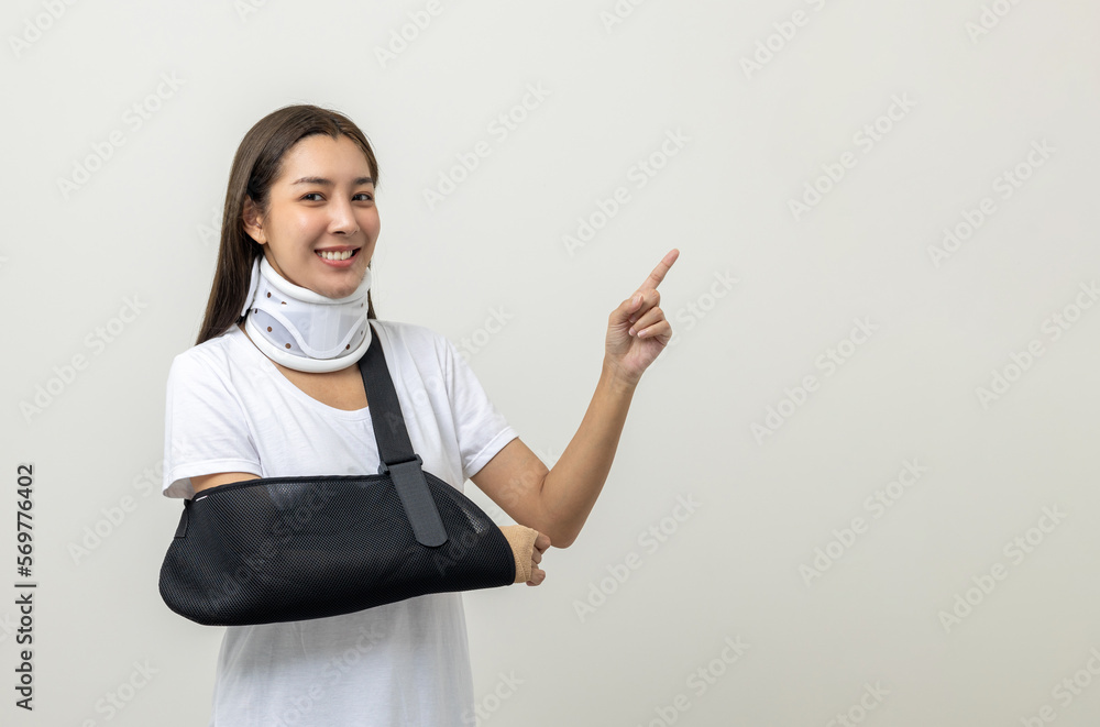 Happy young asian woman broken arm pointing finger on isolated ...
