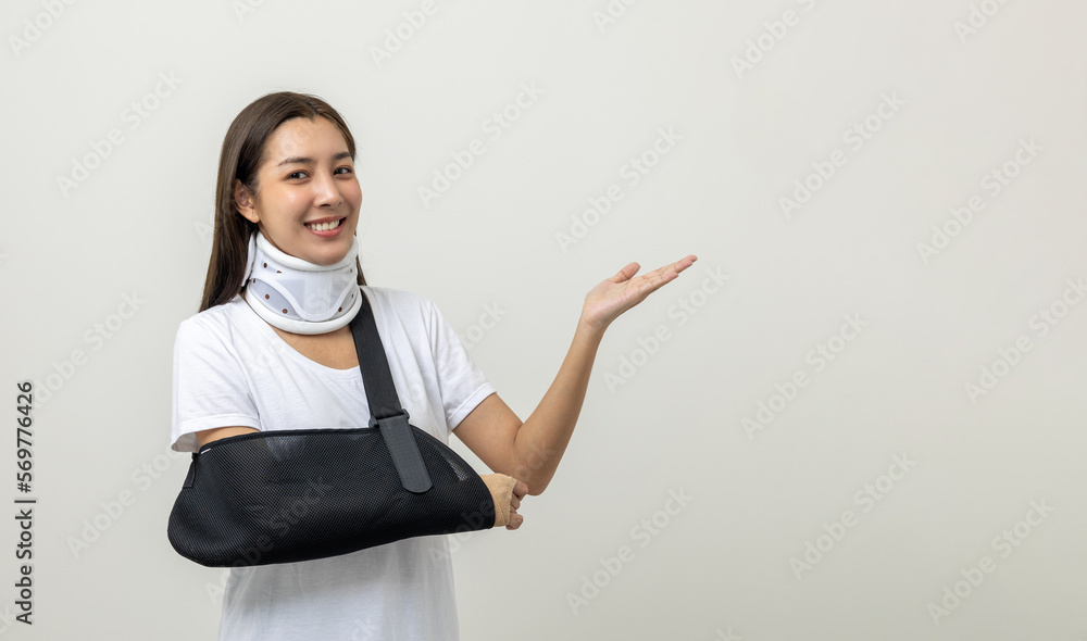 Happy young asian woman broken arm pointing finger on isolated ...