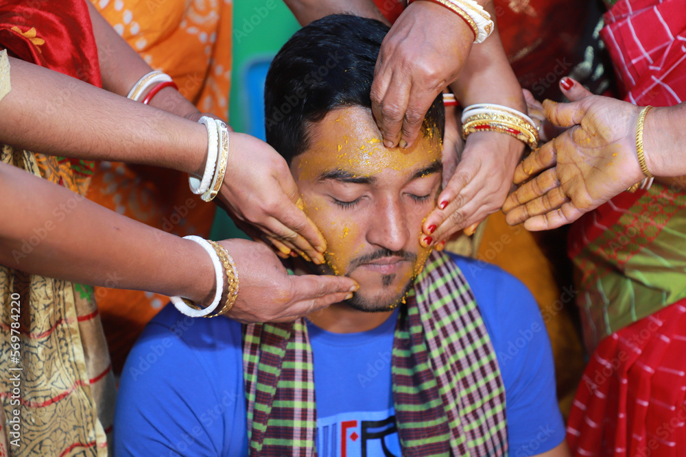 Hindu religious asian groom having bath by her aunts in his pre wedding ...