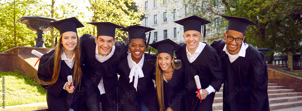 Group of happy diverse university graduates in green campus yard ...