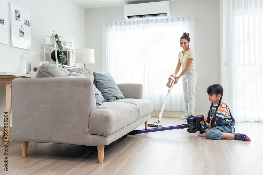 Caucasian beautiful mother cleaning house with young kid daughter ...
