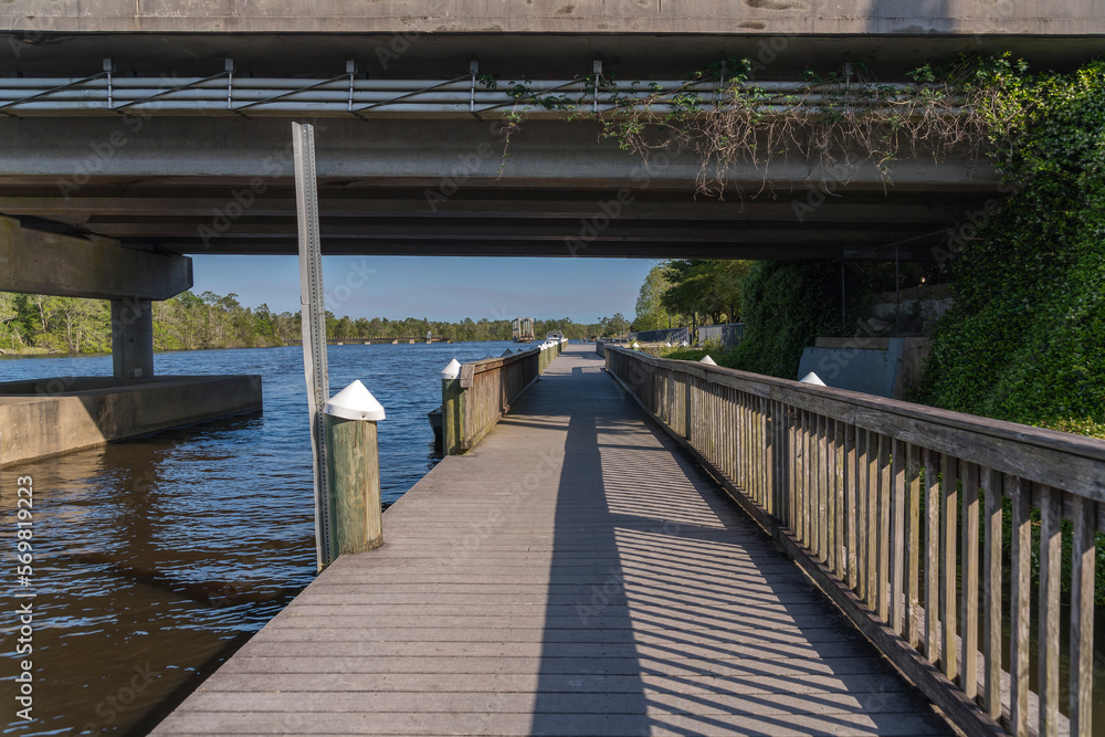 Boardwalk with pillars and railings along the river at Milton, Florida ...