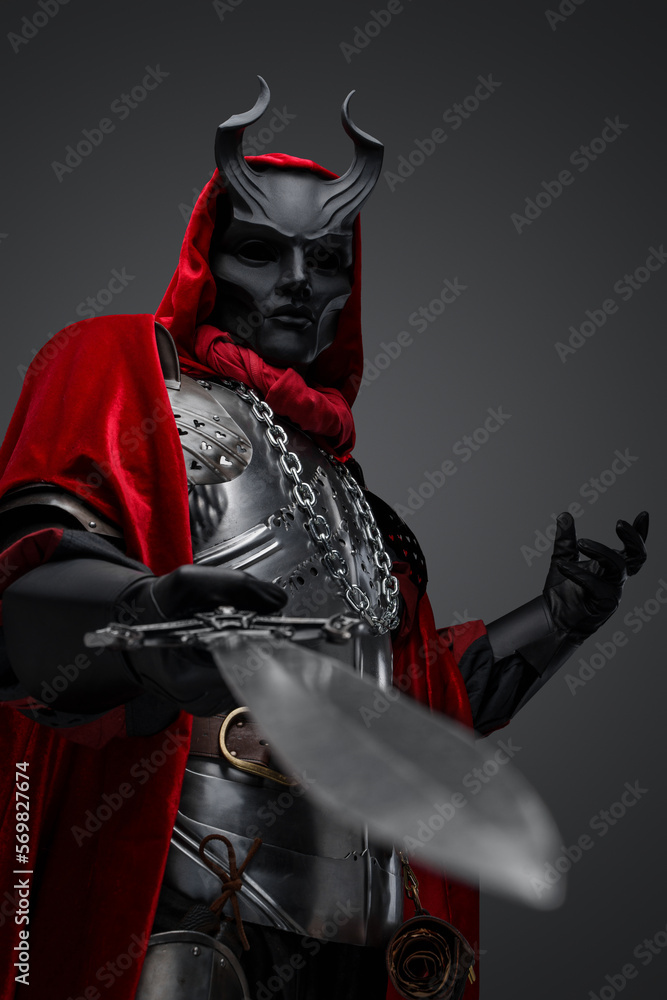 Portrait of evil knight with black mask pointing his sword to camera ...