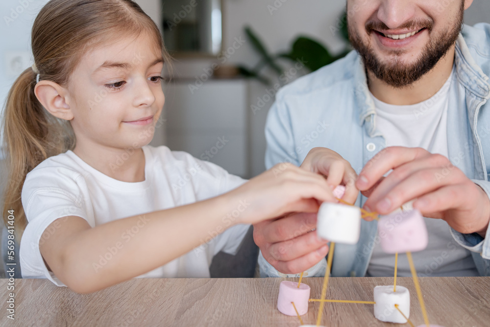 Child girl with father make model of molecule at home. child learning ...