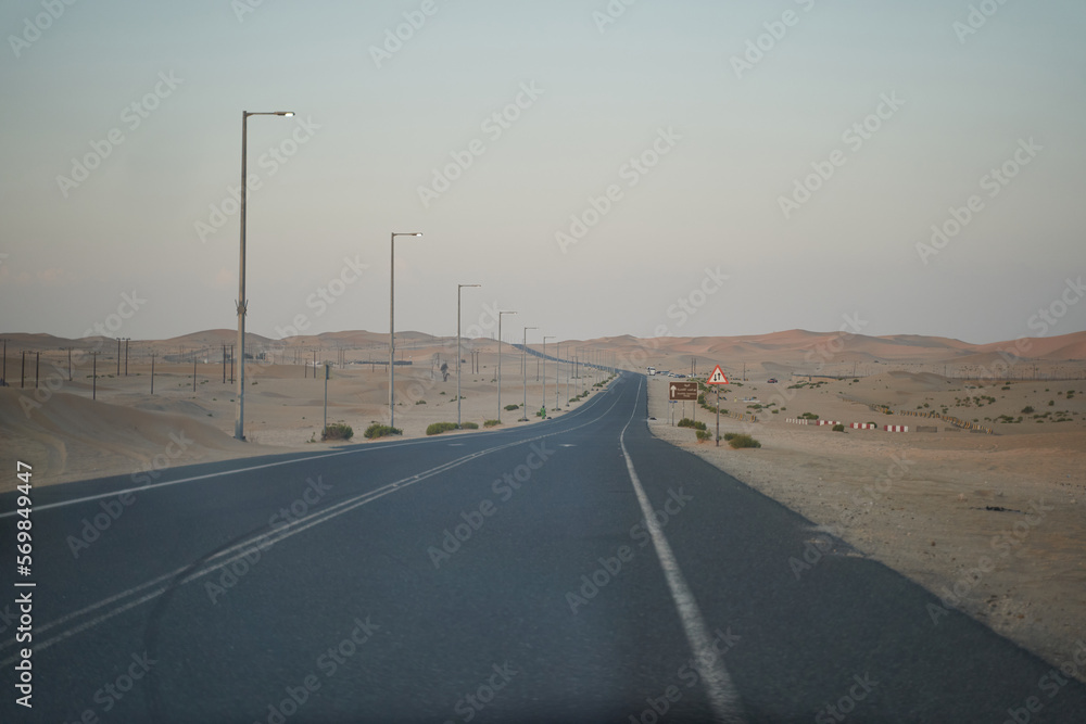 Asphalt road among the desert with traffic signs. Stock Photo | Adobe Stock