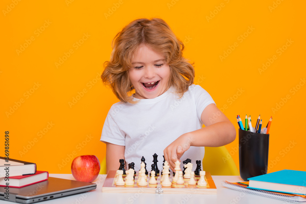 Child with chess on yellow isolated studio background. Kid playing ...
