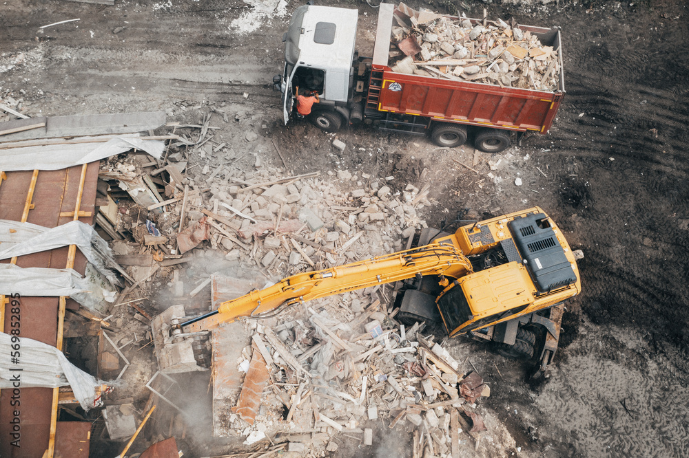 Demolition of building, aerial top view from drone. Excavator breaks ...