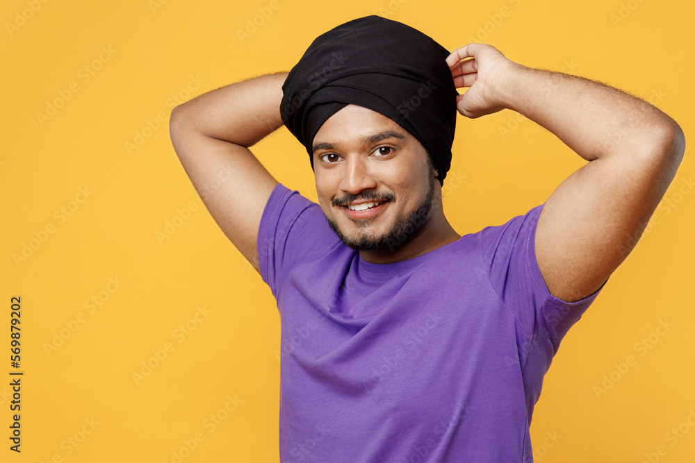 Smiling happy fun cheerful devotee Sikh Indian man ties his traditional ...