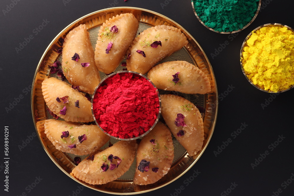 Traditional indian sweet mithai mawa gujia pirukiya with color powder ...
