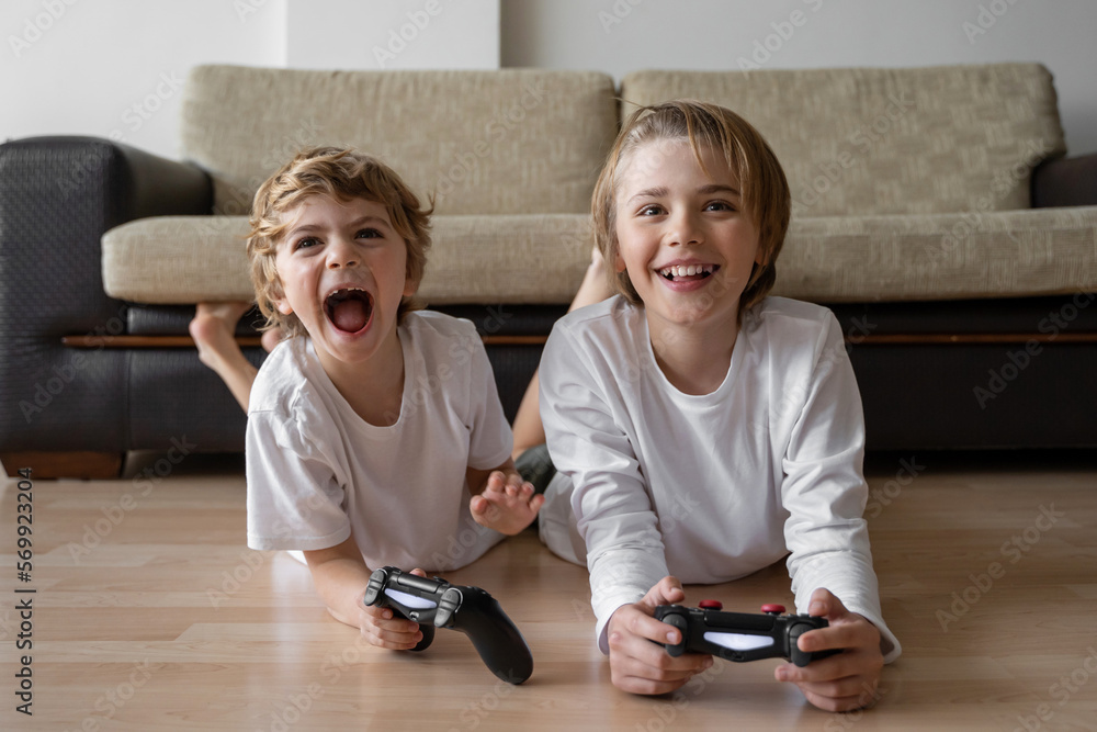 Foto Stock Cute children joyful playing video games with controller ...