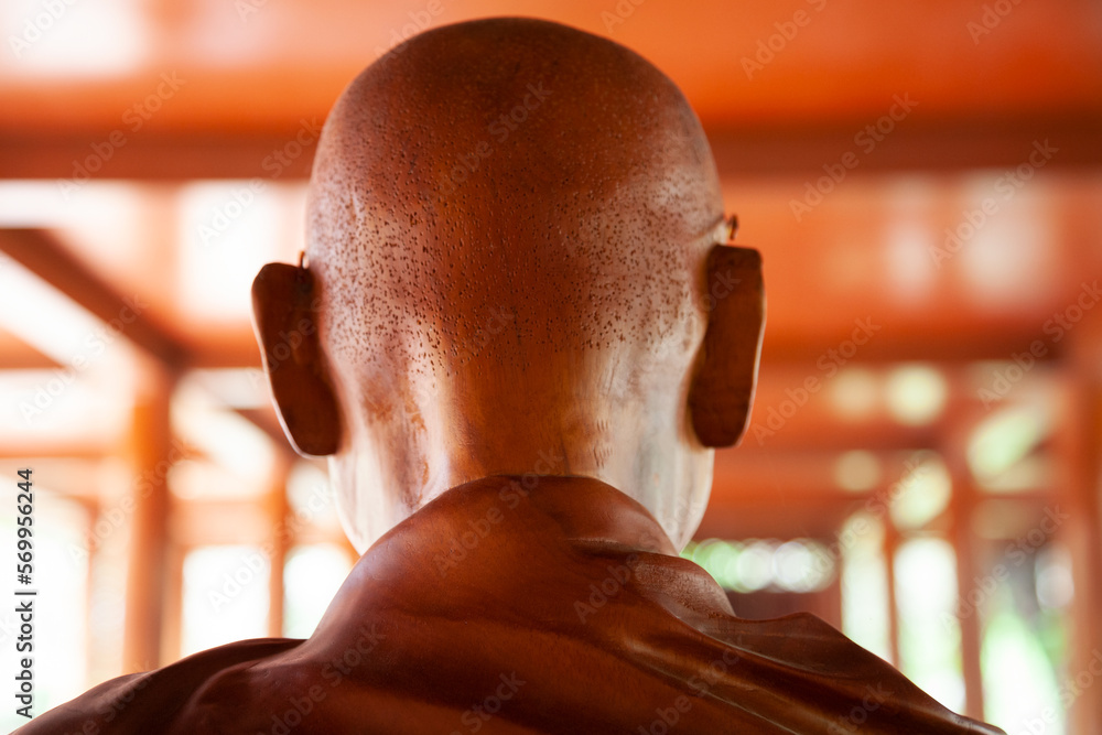 Wooden sculpture of a bald person seen from behind. Back of a head of a ...