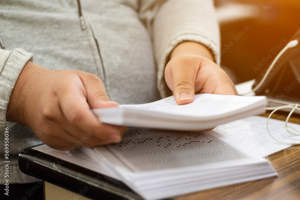 Closeup of hands of teacher holding answer sheet of final test and ...