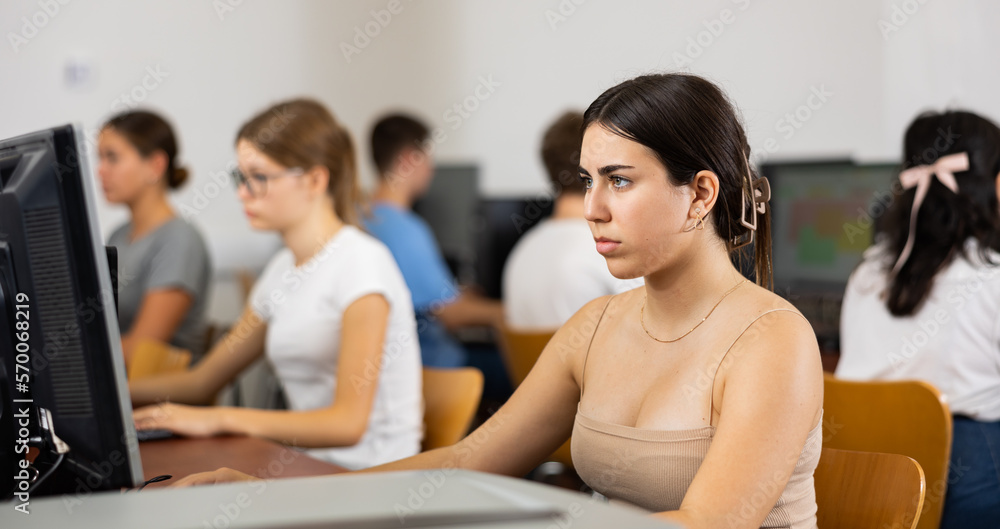 Side view on diligent college girl studying using pc in computer class ...