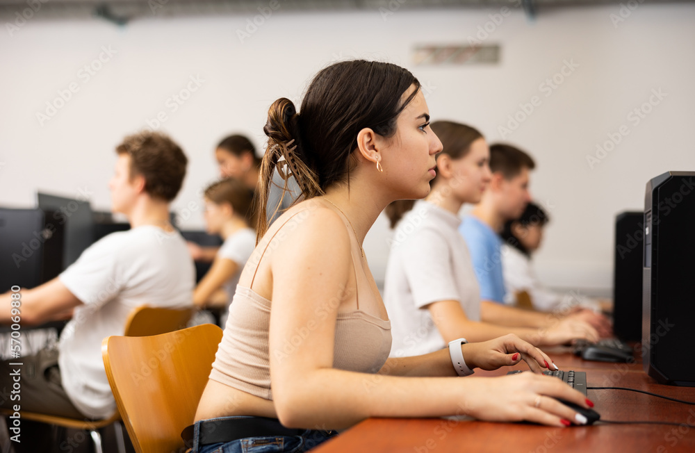 Side view on diligent college girl studying using pc in computer class ...