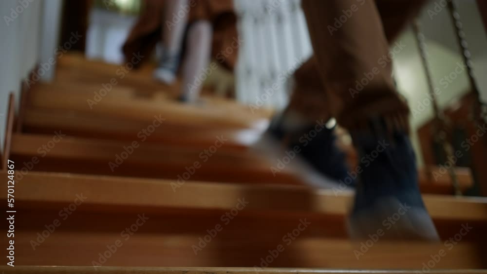 Unrecognizable boy and girl running downstairs in slow motion leaving ...