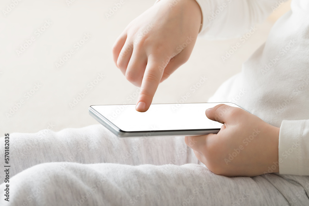 Little baby sitting and holding smartphone and touching white screen ...