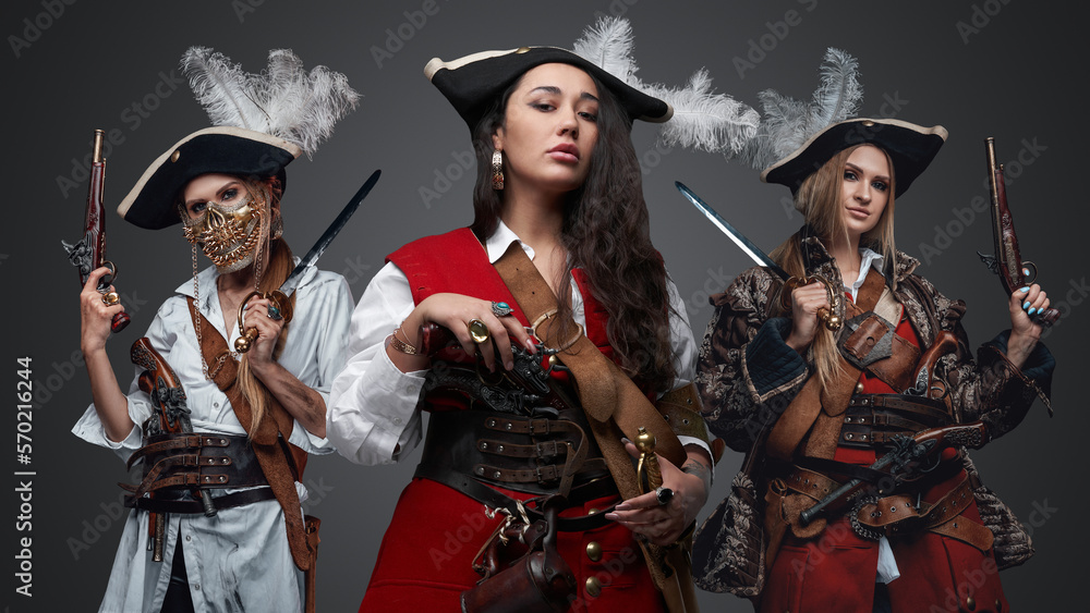 Shot of attractive female buccaneers dressed in antique attire with ...