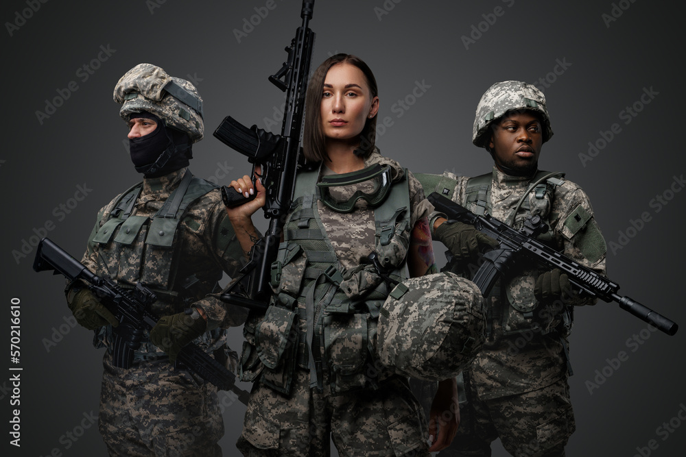 Shot of multiethnic squad of soldiers dressed in modern uniforms armed ...