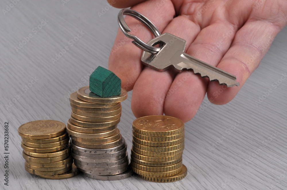 Concept d'immobilier avec une main donnant une clé et une petite maison ...