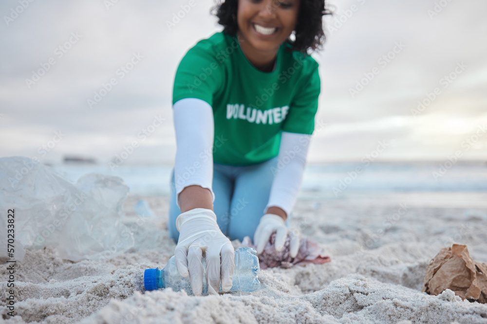 Hand, bottle and a volunteer woman on the beach for community, charity ...
