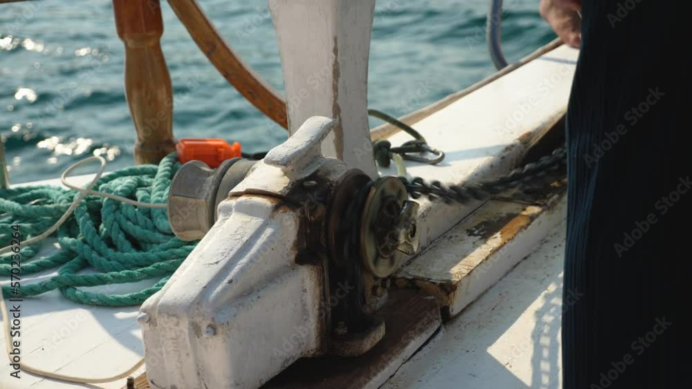 Close-up of the anchor chain sliding on the tensioning pulley while the ...