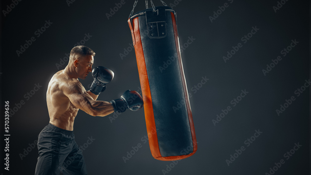 Foto de Boxer in action. Muscular shirtless male boxer exercising at ...