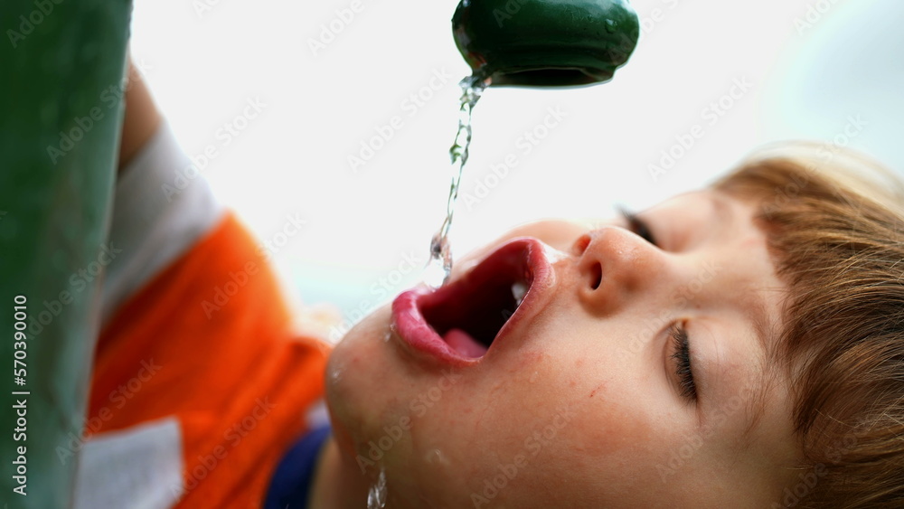 Little kid boy drink water at fountain in slow motion. Sunny summer day ...